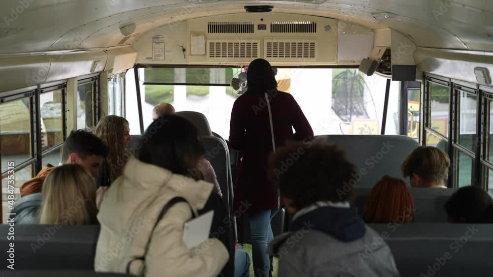 Multiracial secondary school pupils getting up and walking to exit from ...