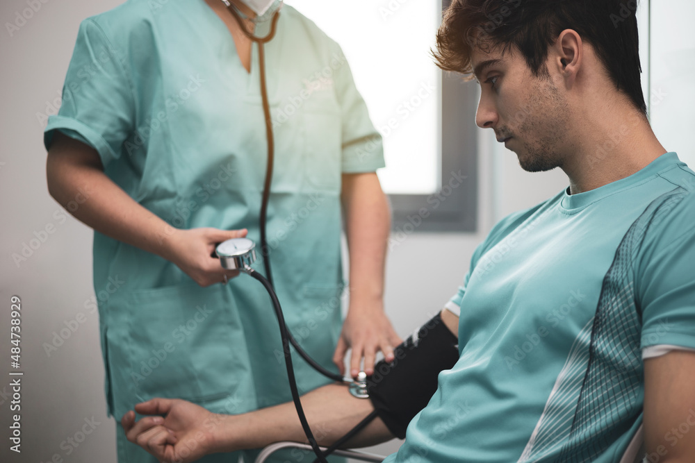 Doctor taking blood pressure and pulse on the arm of a patient in the ...
