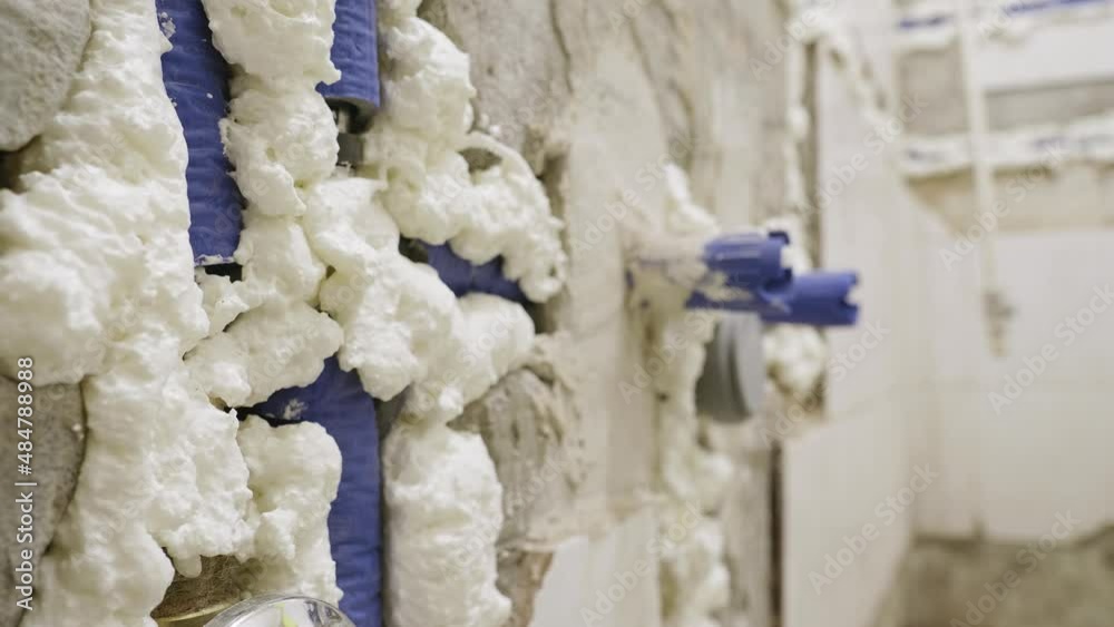 An extreme close up shot of blue water pipes covered in white expanding ...