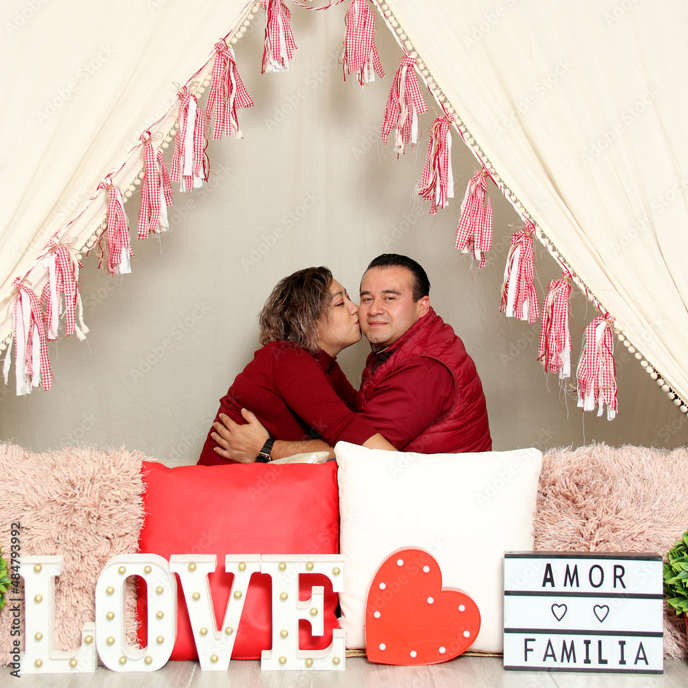 Latin Hispanic adult couple demonstrate love under a teepee with a sign ...