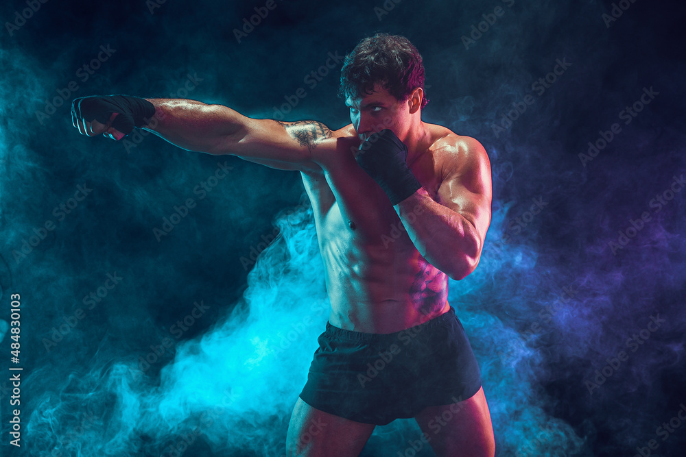 Half length of athlete boxer who training and practicing jab on smoke ...