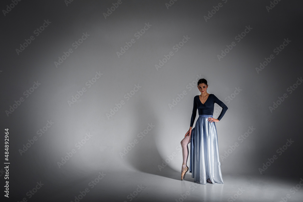 young pretty, fragile, beautiful ballerina dancing in a long blue dress ...