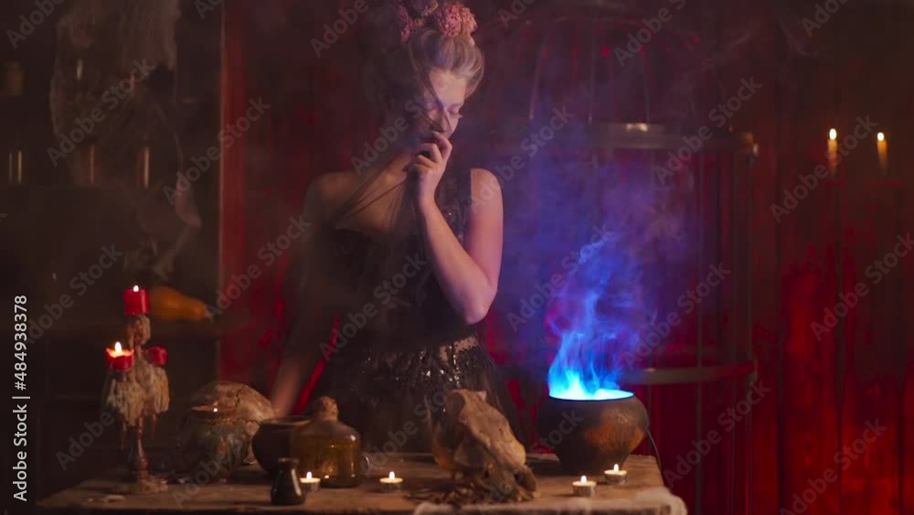Halloween witch with cauldron hide face Beautiful young woman flowers ...