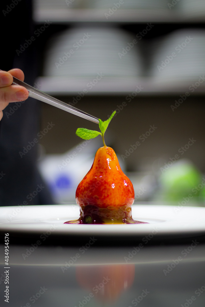Dressing of a pear entremet and its fruit coulis poses mint with ...