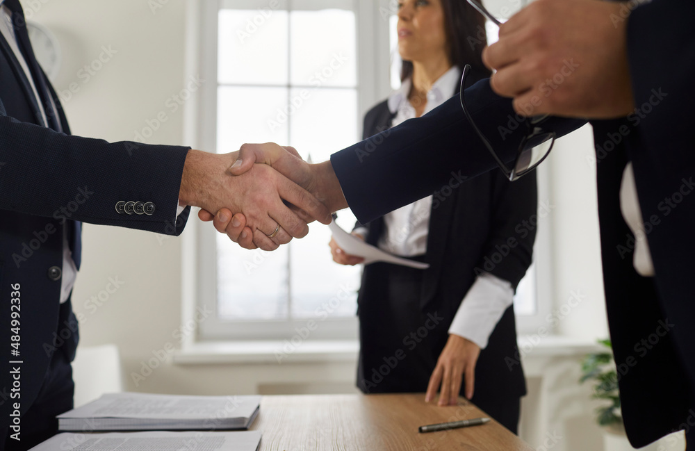 Lawyer shaking hands with his client. Two people in suits make a deal ...