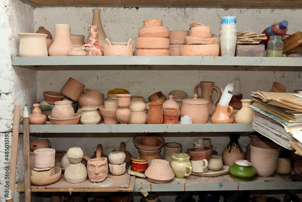 Wooden shelf with pottery in the pottery workshop. Different pieces and ...