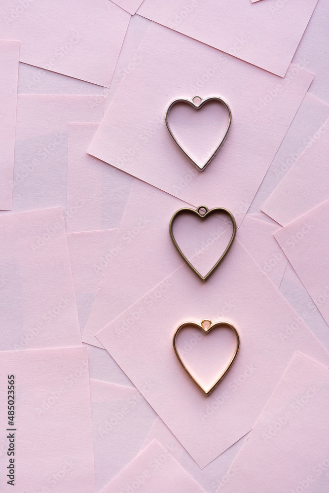 Foto de tres corazones sobre fondo de papelitos post its rosados ...