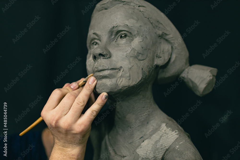 Man sculptor creates sculpt bust clay human woman sculpture. Statue ...