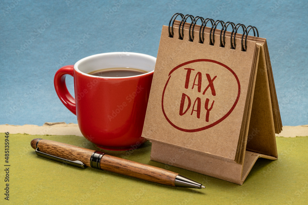 tax day note- handwriting in a spiral desktop calendar with a cup of ...
