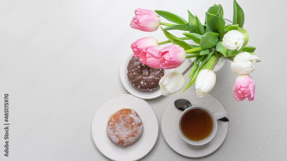 Vidéo Stock Donuts, a cup of coffee are moving on a light background ...