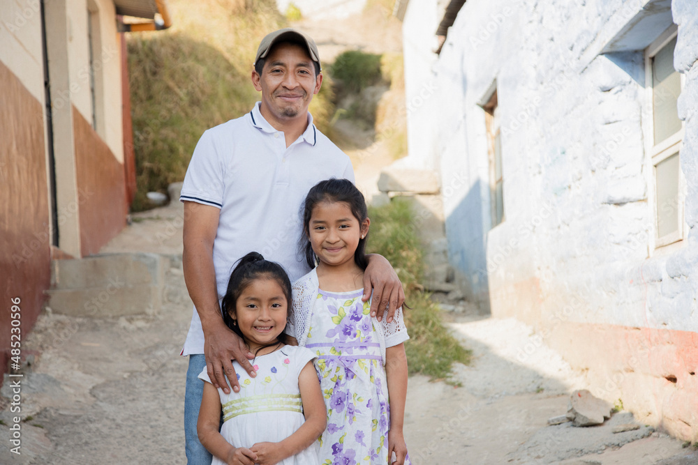 Latino father with his two happy daughters outside his house in rural ...