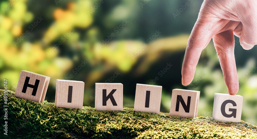 hiking word text on cubes on a forest background. Man walking, mountain ...
