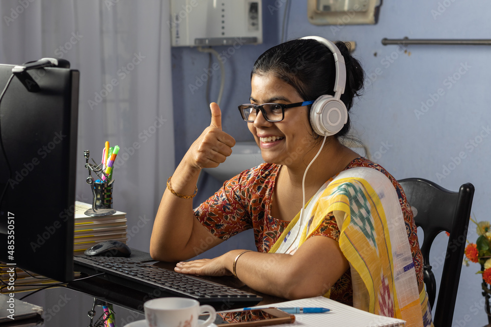 Indian woman in saree working on computer and talking over internet ...