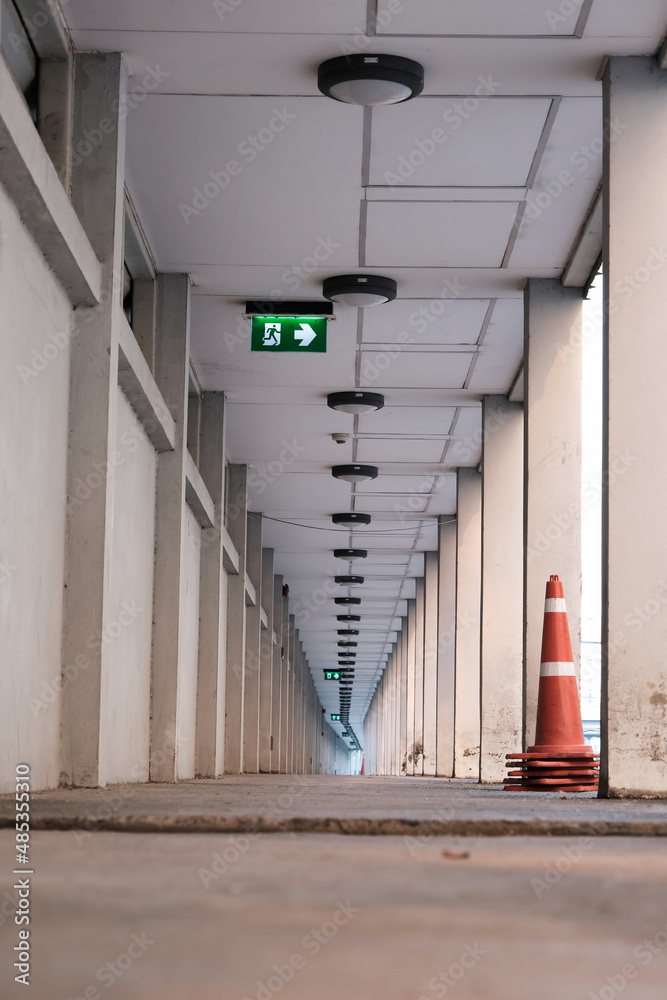 Low angle green fire exit signs and red cones along the walkway. Stock ...