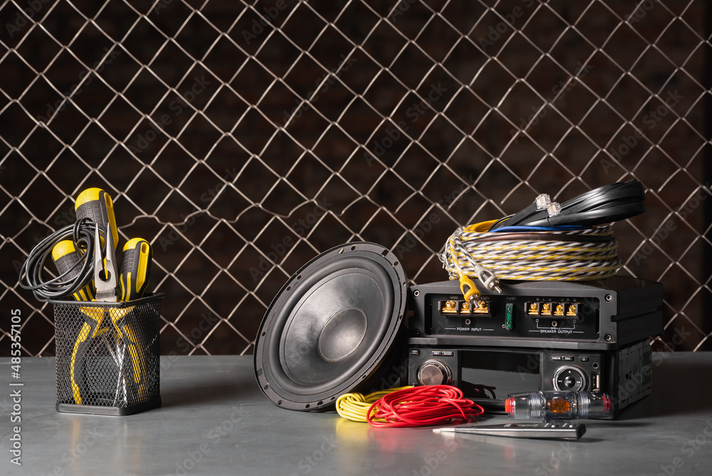 Car stereo system components and work tools on the metal workbench ...