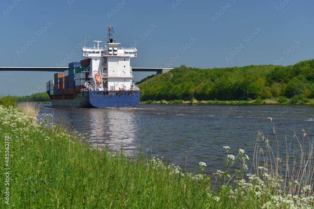 Containerschiff fährt unter Brücke im Nord-Ostsee-Kanal Stock Photo | Adobe Stock