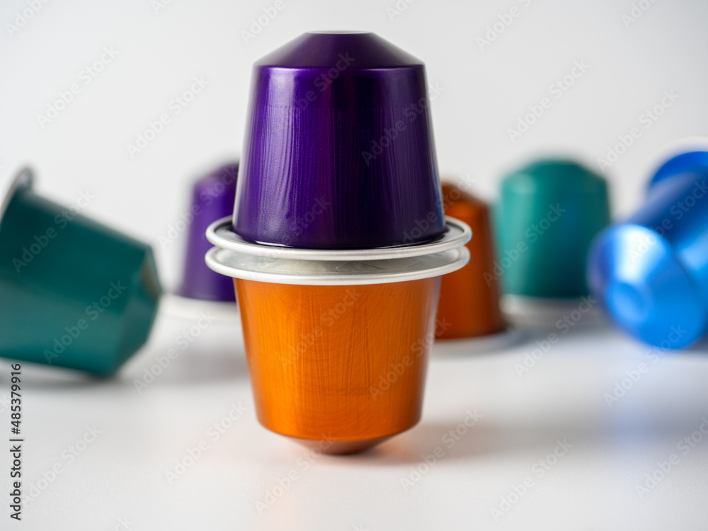 Aluminum capsules of orange and purple color with ground coffee for ...