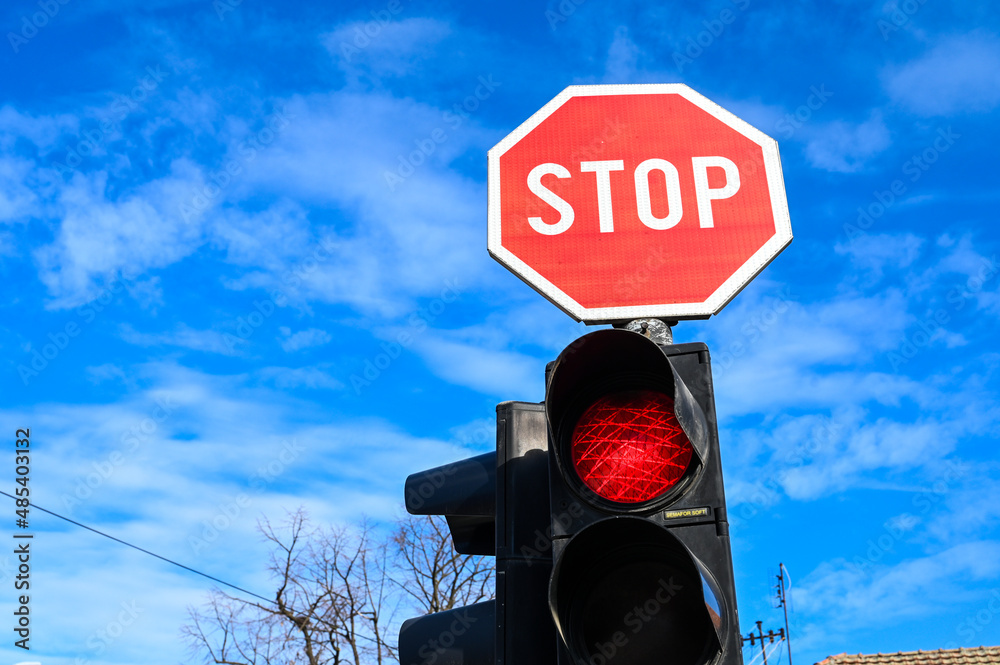 Stop sign and red light at a traffic light at an intersection. Red stop ...