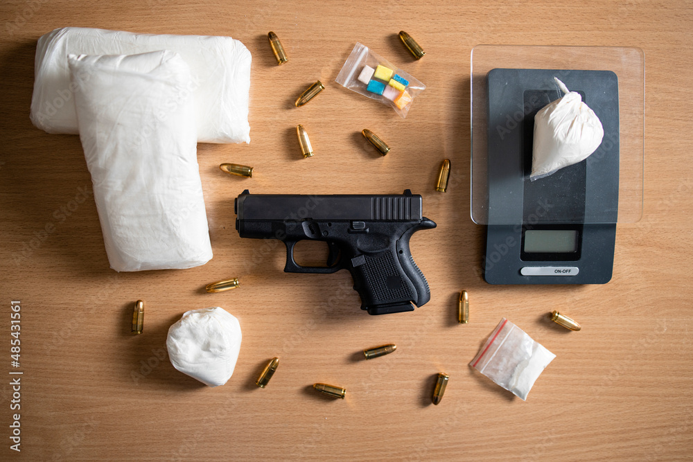 Guns and drugs concept - top view of cocain packages, scale and gun ...
