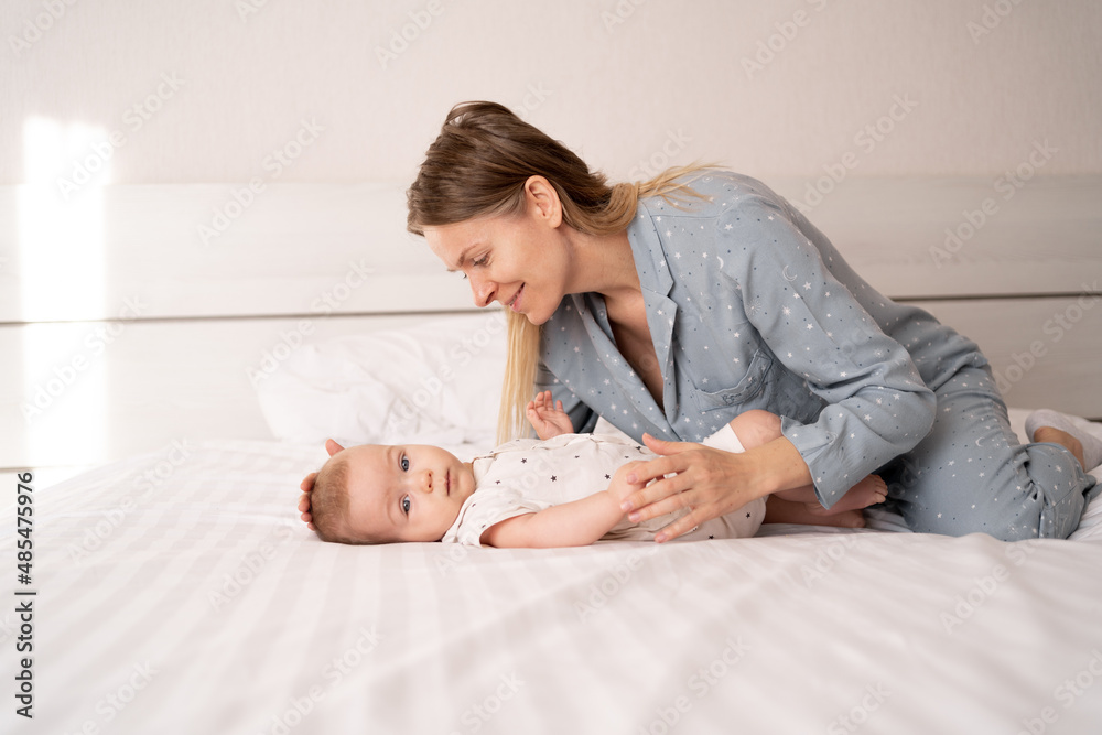 Happy family. Laughing young mother looking at her adorable newborn son ...