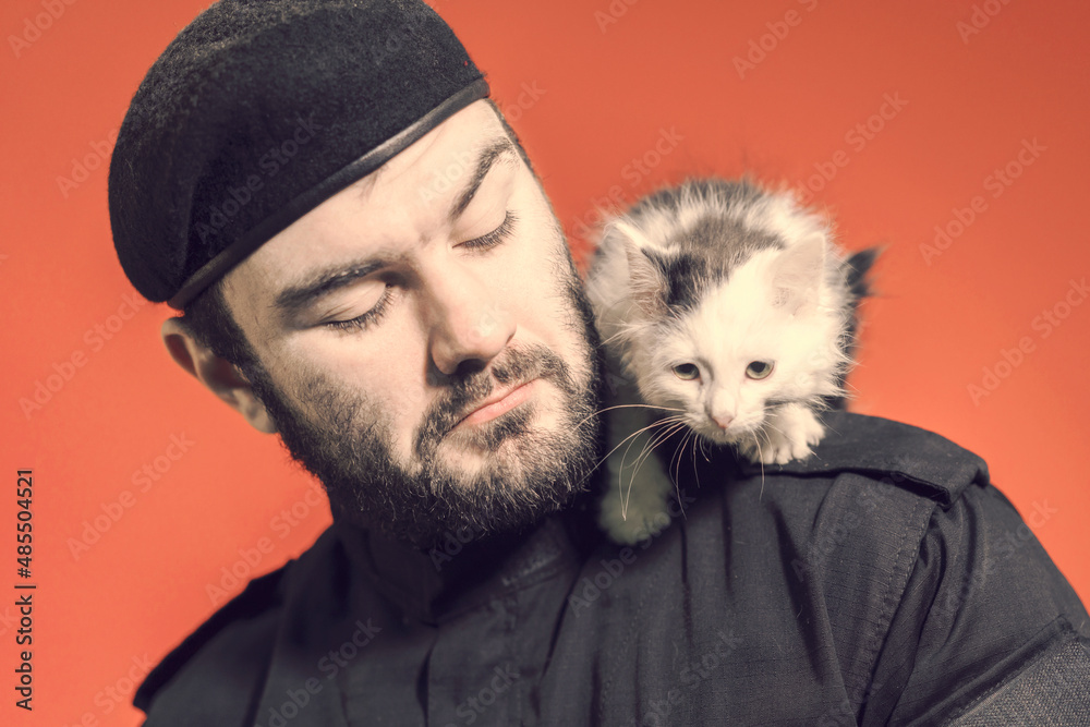 Fotografia do Stock: The bodyguard interacts with the cat. Military ...