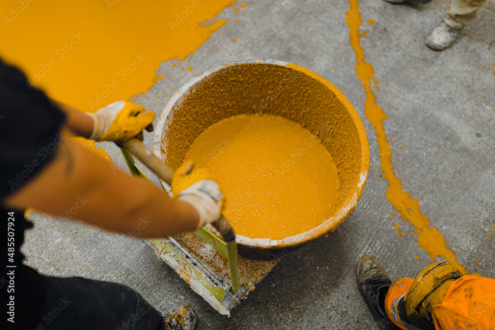 epoxy flooring applicator performs painting works with polyurethane ...