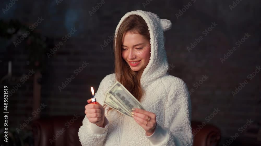 Young woman burns dollars. Beautiful caucasian female dressed white ...