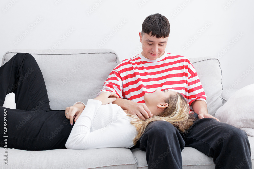 Romantic scene of a young couple in the sofa. Girl lying on her ...