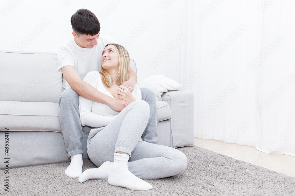 Boyfriend sitting in the sofa and girlfriend sitting between his legs ...