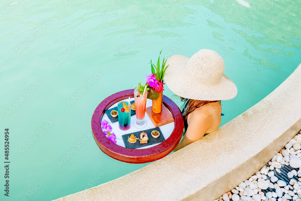 cute teenage girl with served floating tray in swimming pool with ...