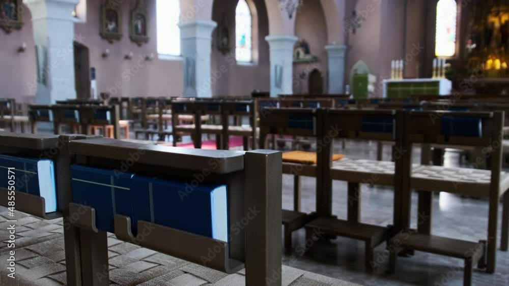Empty catholic cathedral inside, wooden benches for prayers, ornament ...