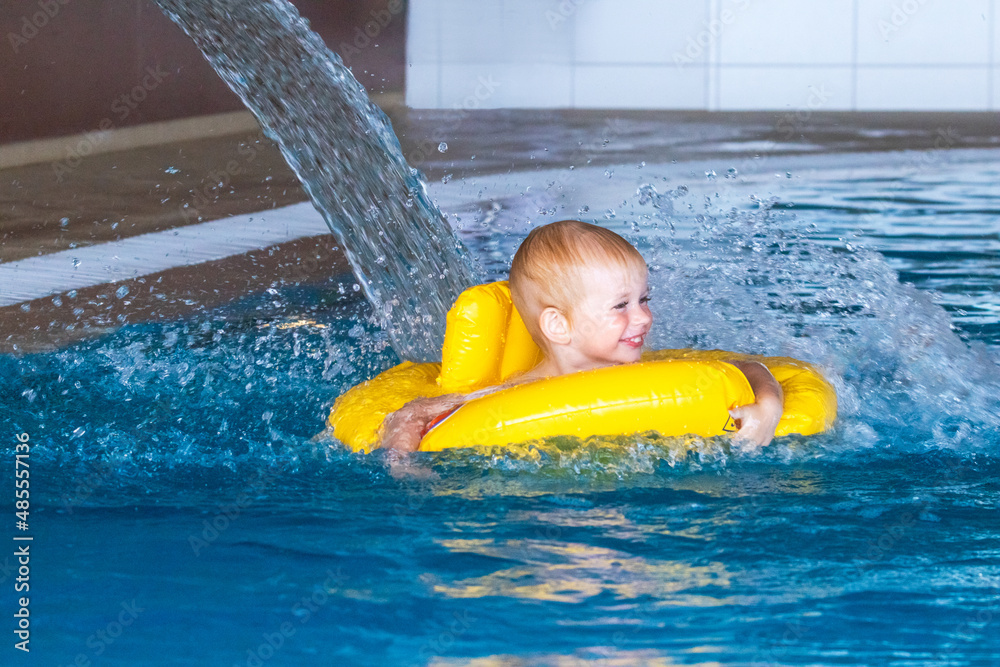 Toddler boy swimming with inflatable floatie in swimming pool in spa ...