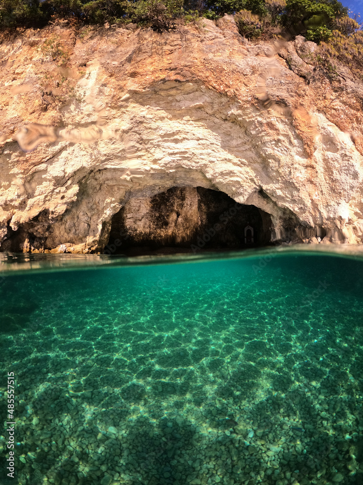 Underwater split photo of small white rock cave with crystal clear ...