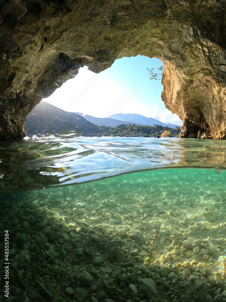 Underwater split photo of small white rock cave with crystal clear ...