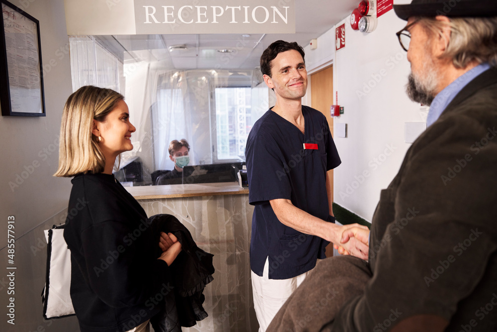 Patients and doctor at reception desk Stock Photo | Adobe Stock