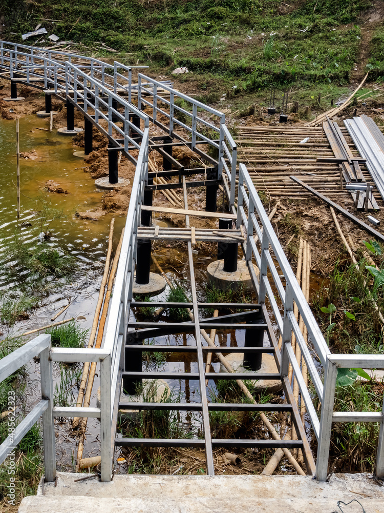 Construction of pedestrian bridge along the reservoir. The structure of ...