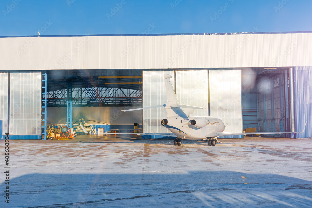 Gate open hangar and outside a small jet ready to roll in. Stock Photo ...