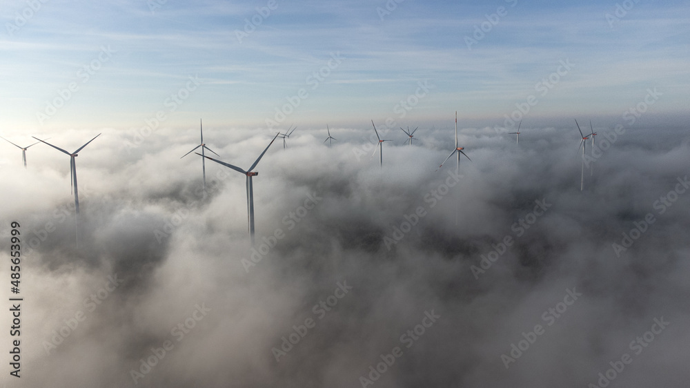 Wind turbines shrouded in clouds Stock Photo | Adobe Stock