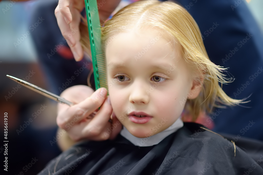Preschooler boy getting haircut in barbershop. Children hairdresser ...