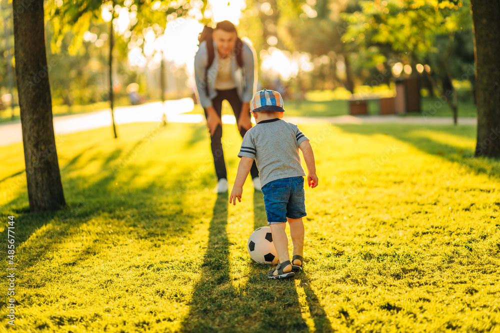Dad and son with a soccer ball in the park. Football field Father son ...