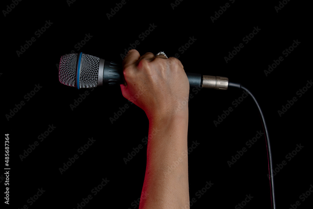 Mano sosteniendo microfono dinámico en señal de protesta. Podcast y ...