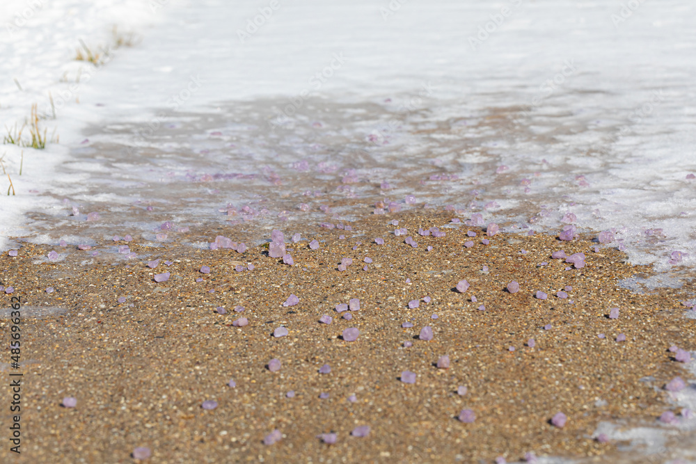 Ice melt salt melting ice and snow on sidewalk. Snow removal, melting ...