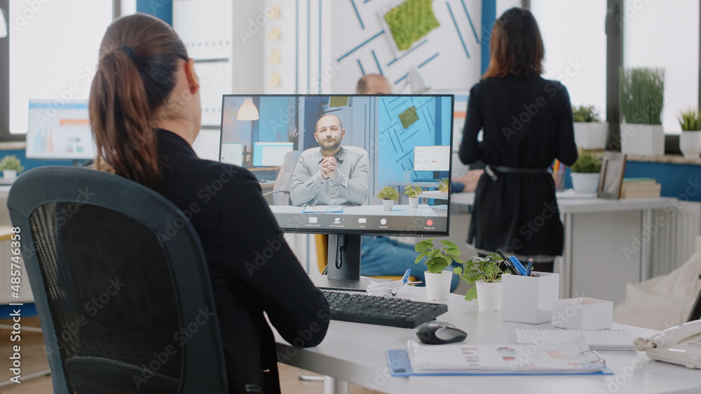 Businesswoman using video call on computer for conversation with ...