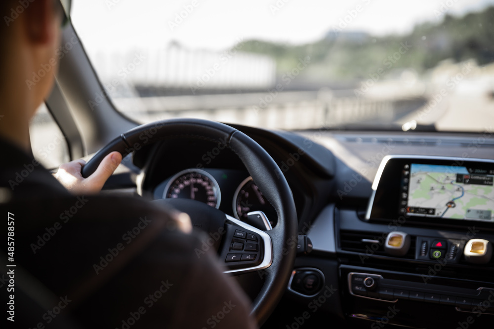 Driver at a steering wheel of a modern car (shallow DOF; color toned ...