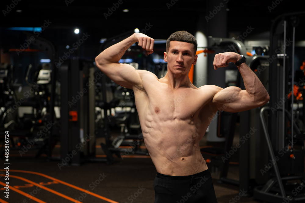 Strong man with muscular torso flexing arms muscles showing double ...