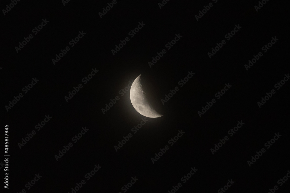 The moon in its waning phase, almost in its half, in the center of the ...