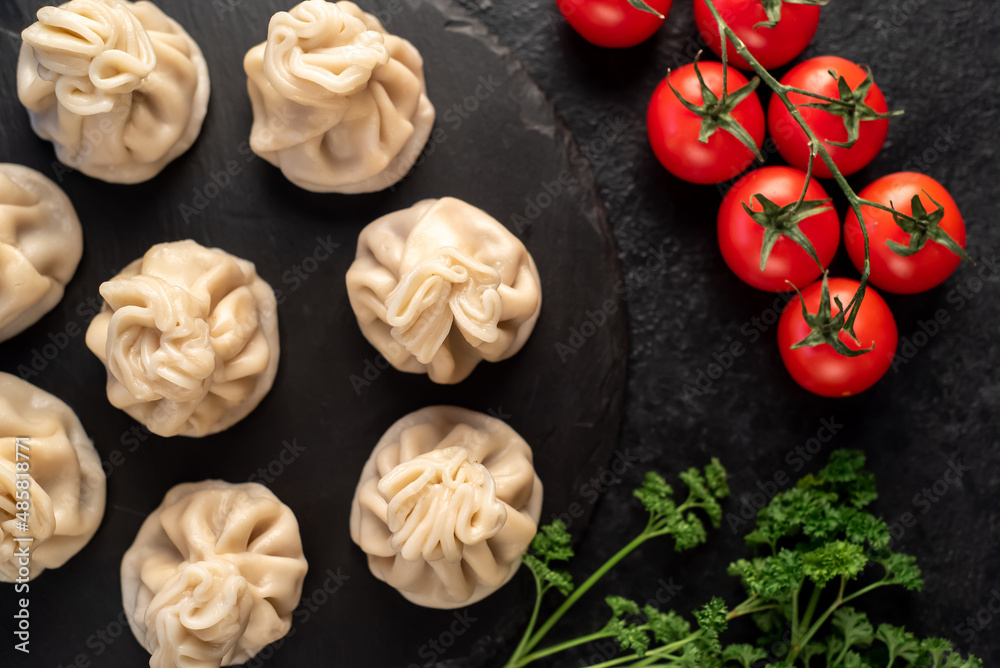 Khinkali, Georgian dumplings with meat filling on a stone background ...