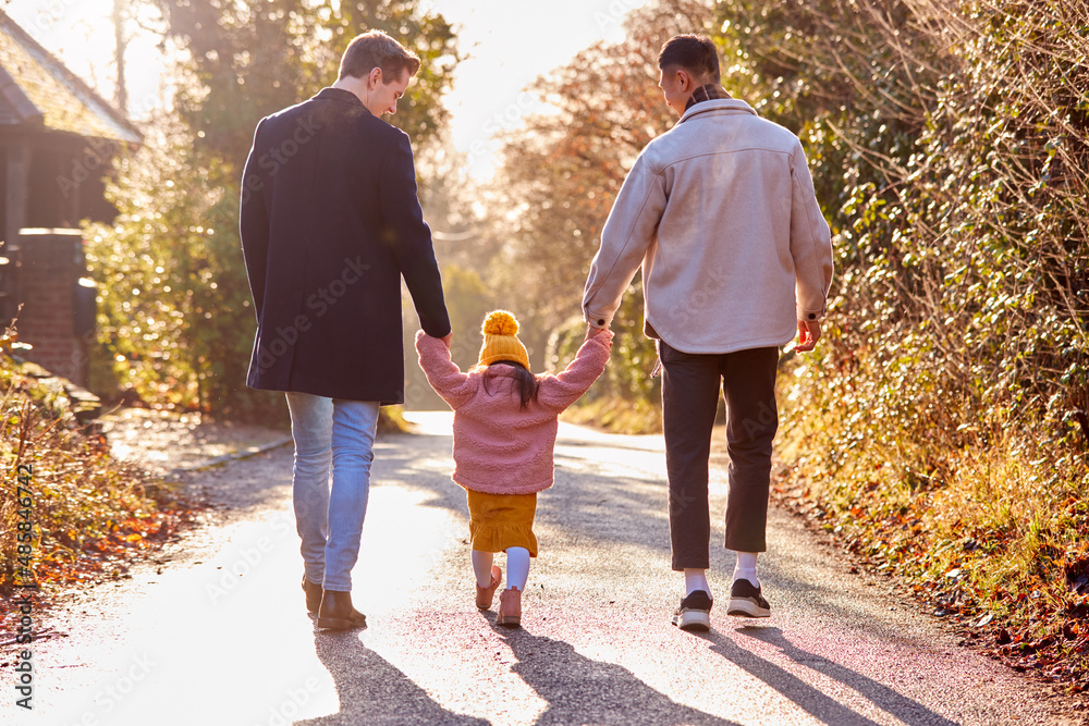 Rear View Of Family With Two Dads Taking Daughter For Walk In Fall Or ...