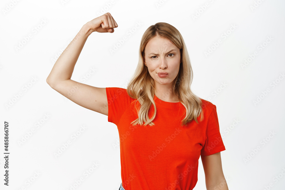 Strong women. Happy young smiling fit girl, showing muscles, raising ...