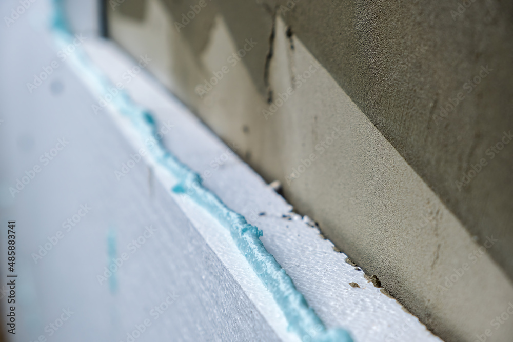 Installation of styrofoam insulation sheets on house facade wall for ...